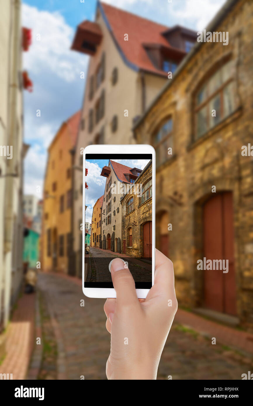A man is making a photo of european street with parked motor scooter in ...