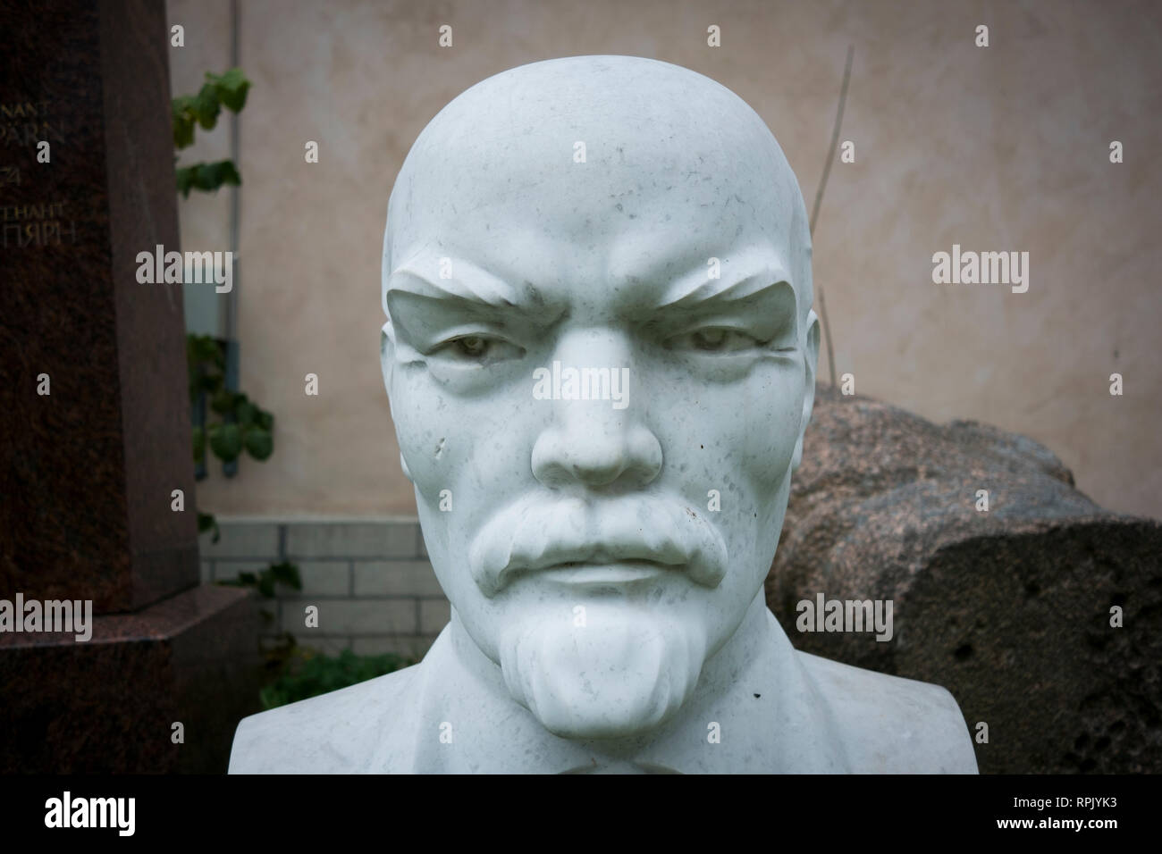 A white marble bust of Vladimir Lenin sits behind a building in Tallin ...
