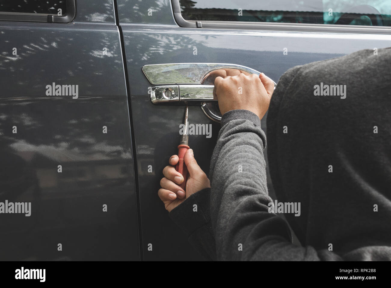 Man burglar stealing car Stock Photo - Alamy