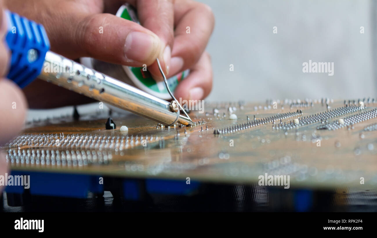The technician repairing the computer mainboard by soldering Stock ...