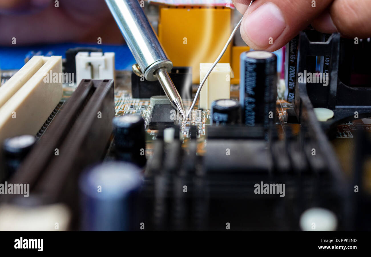 The technician repairing the computer mainboard by soldering Stock ...