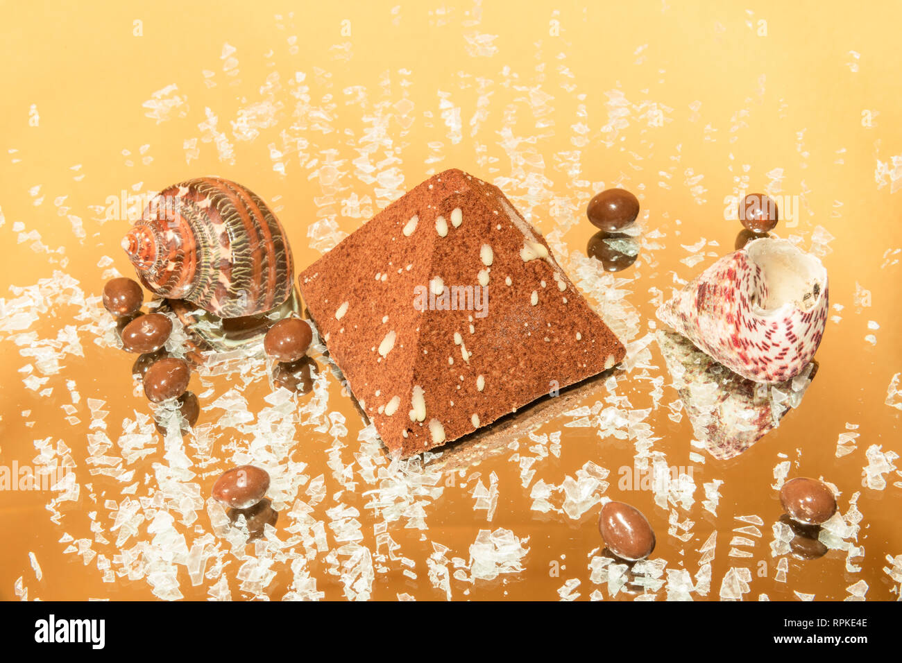 pyramid chocolate mousse cake on a mirror with crushed ice and a clear ...