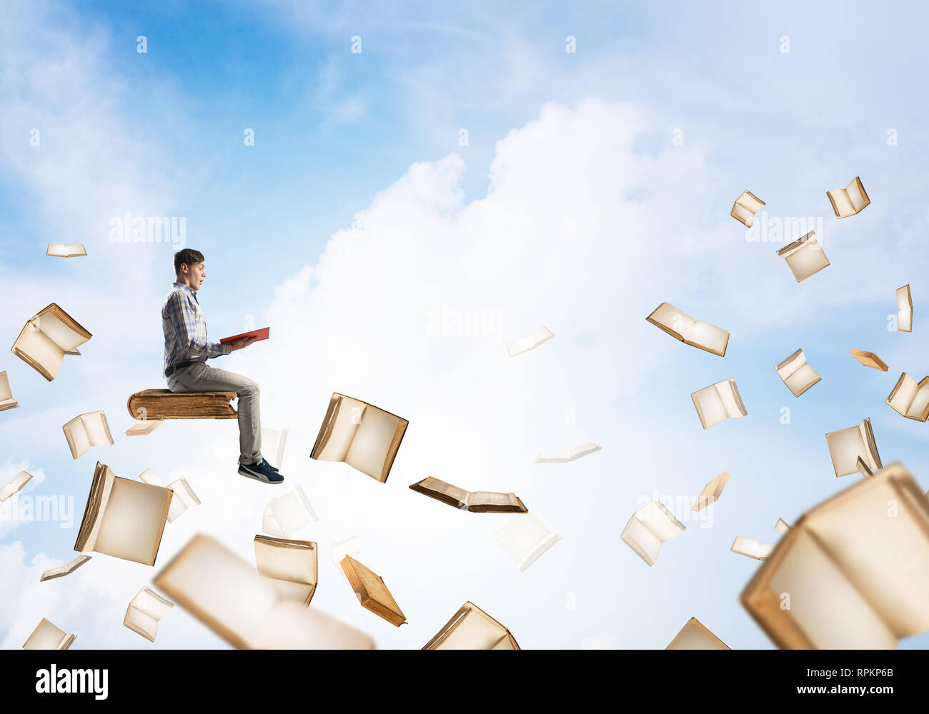 Man reading book and many of them flying in air Stock Photo - Alamy