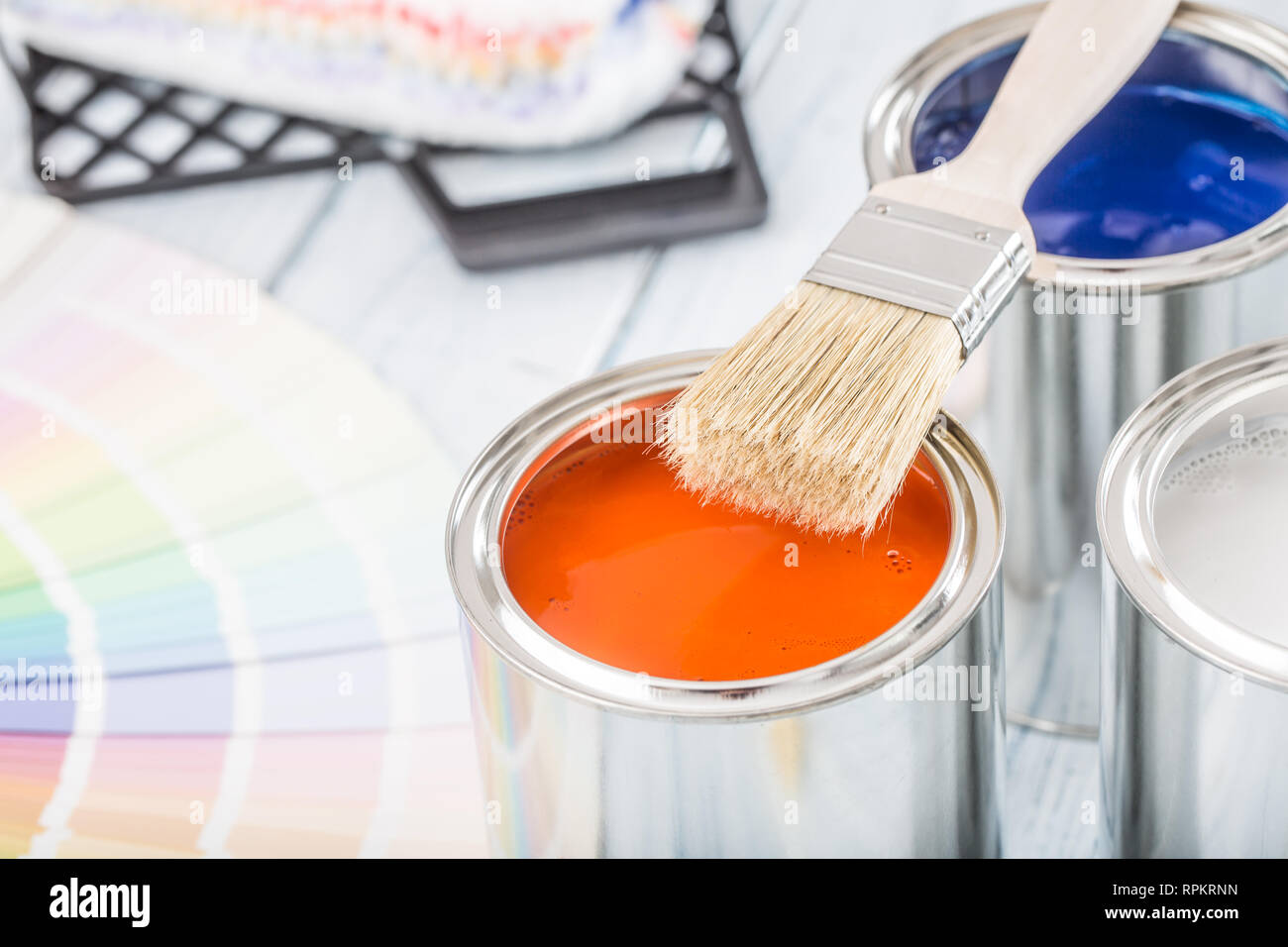 Paint cans brush and color palette on table Stock Photo - Alamy