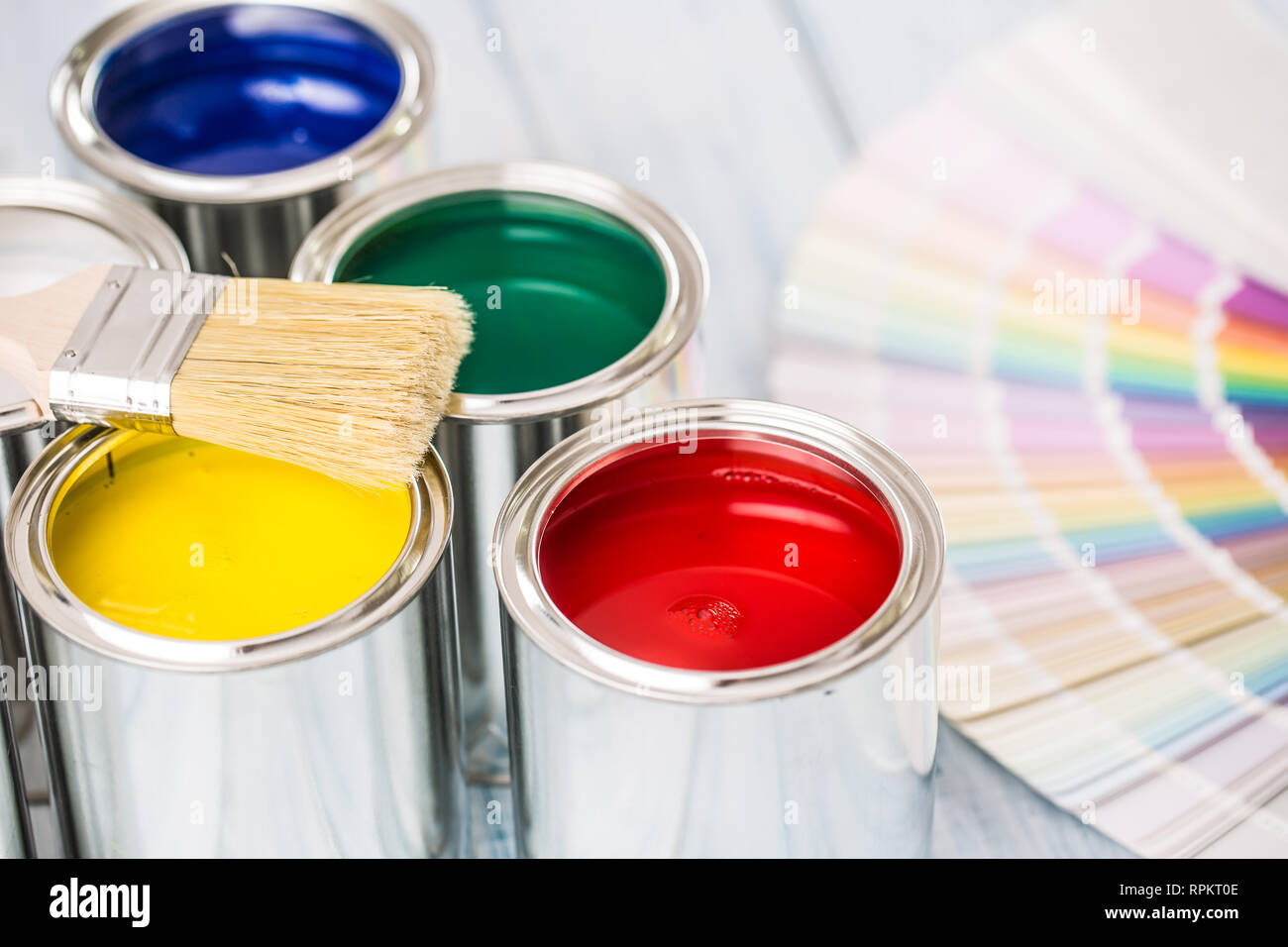 Paint cans brushes and color palette on table Stock Photo - Alamy