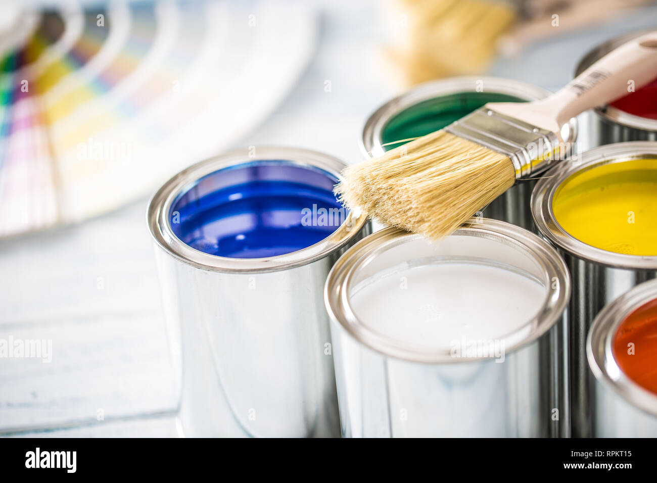 Paint cans brushes and color palette on table Stock Photo - Alamy
