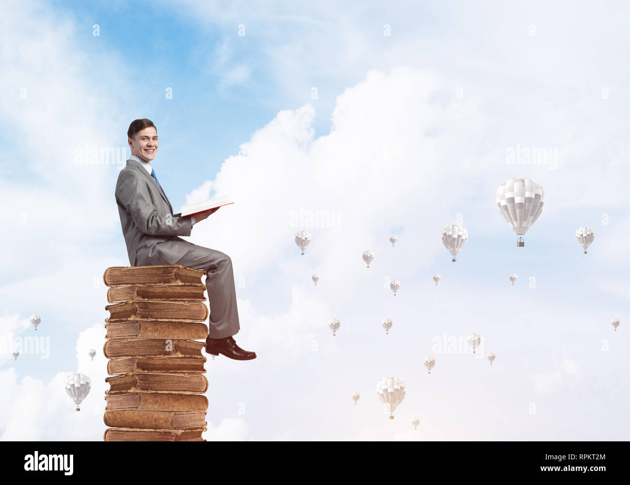 Man student reading book and aerostats flying around in air Stock Photo ...