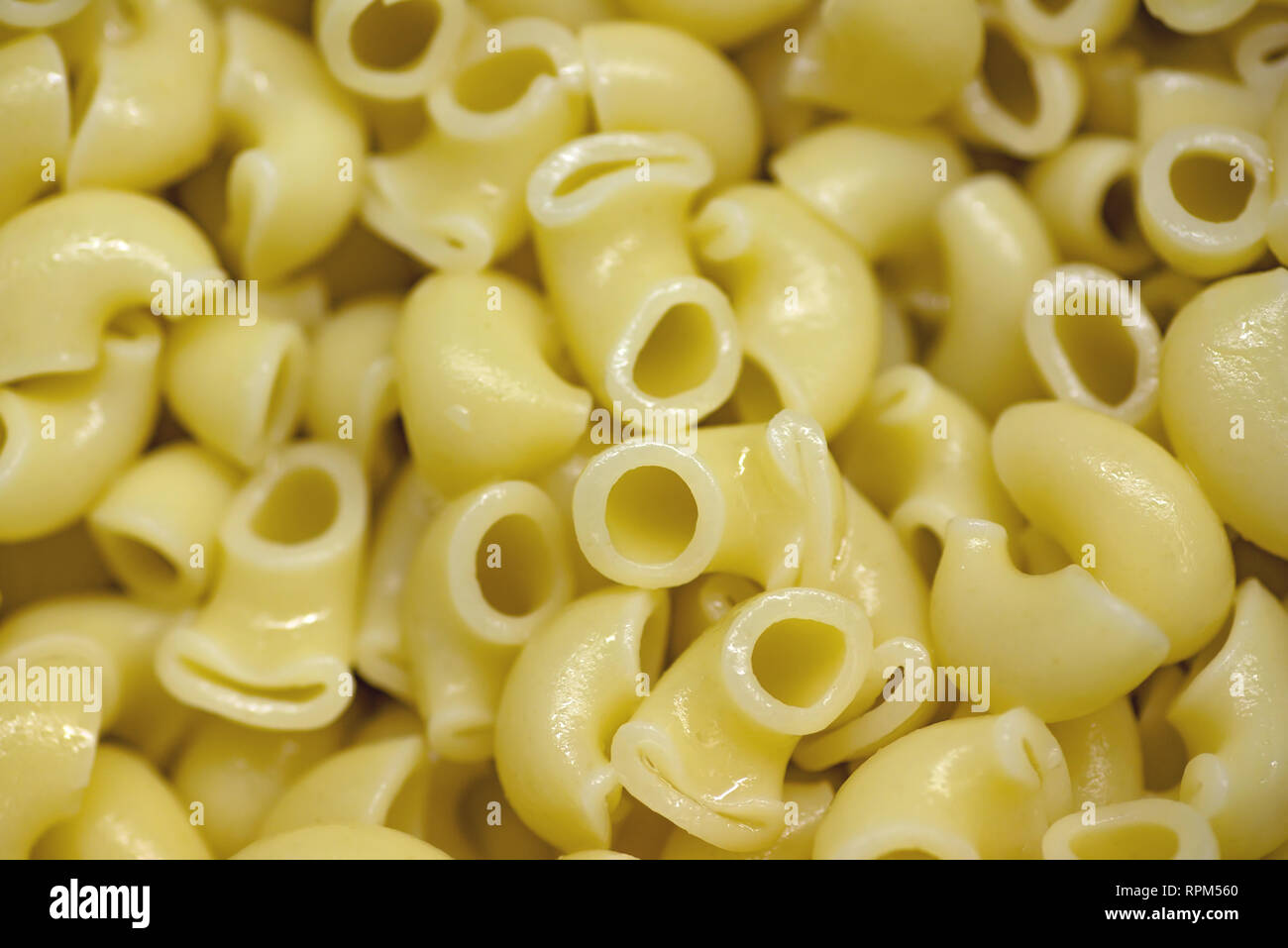 yellow boiled pasta horns scattered texture on the surface Stock Photo ...