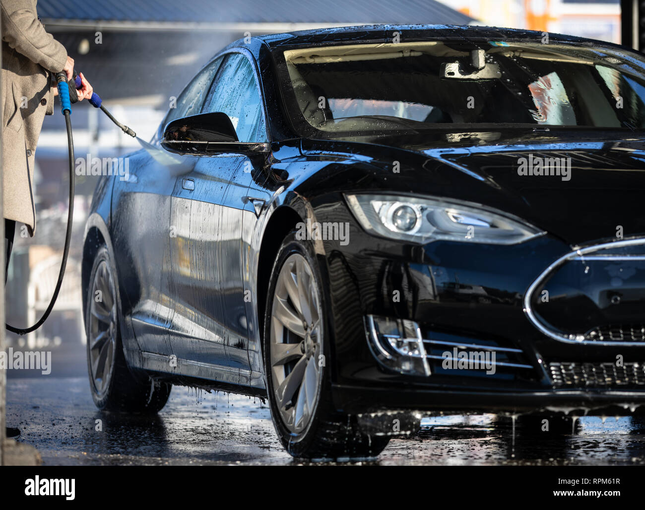 Cute woman washing her car in a manual carwash (color toned image Stock ...