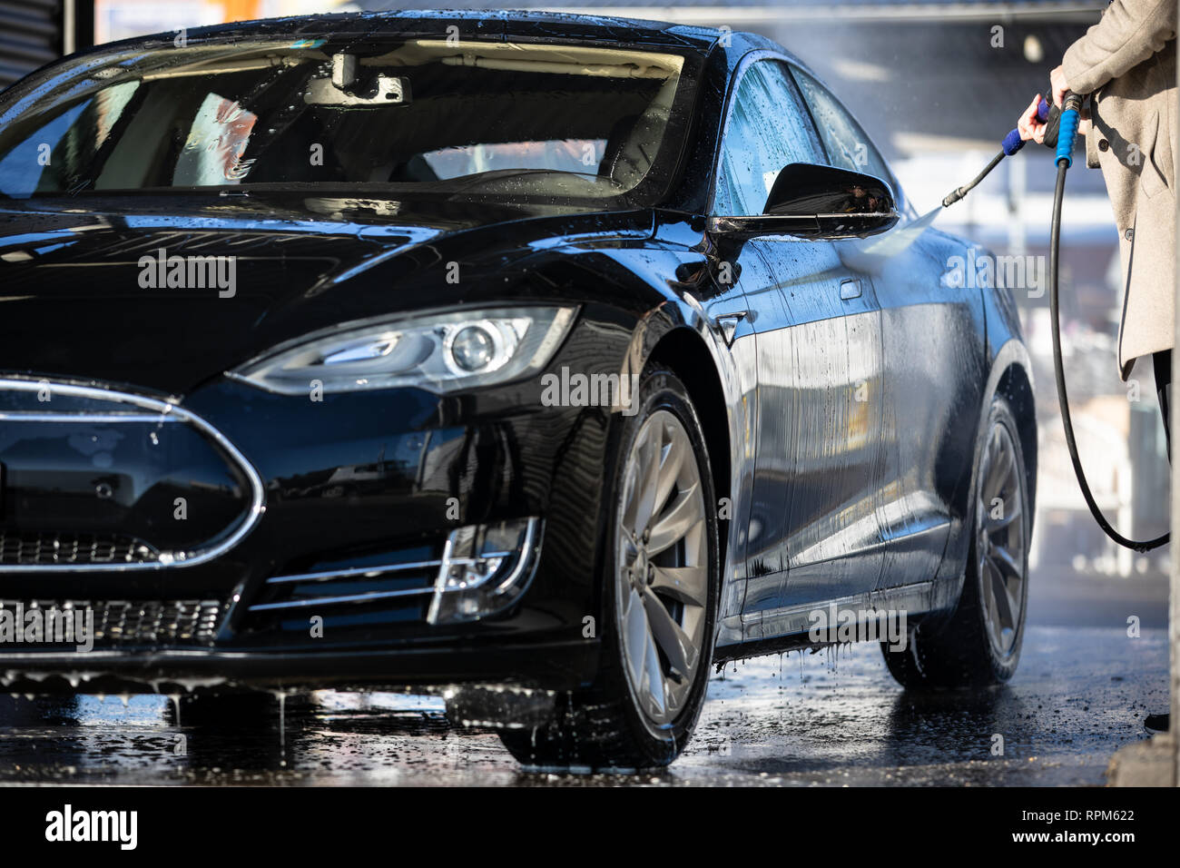 Cute woman washing her car in a manual carwash (color toned image Stock ...
