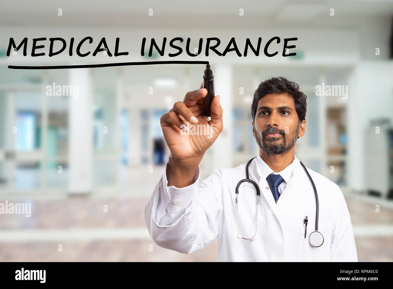 Indian male medic with focused expression using black marker for ...