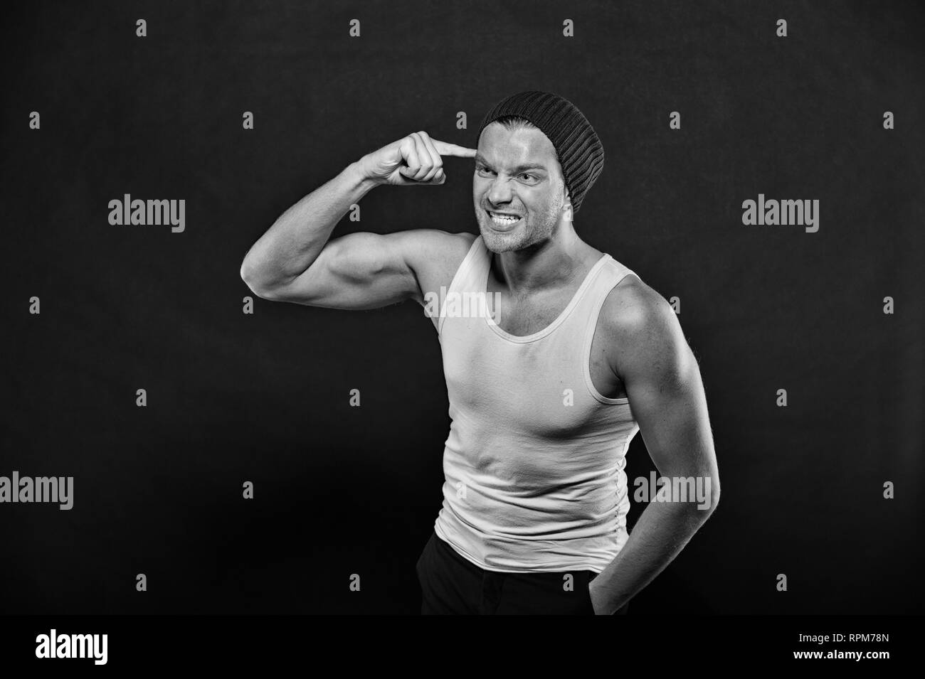 Macho with angry face. Man with finger at head. Athlete in fashion vest ...