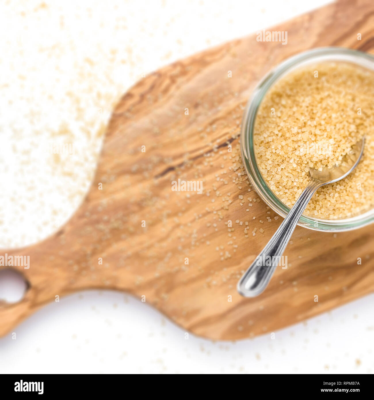 Brown sugar in glass jar on wooden chopping board. Flat lay. Shallow ...