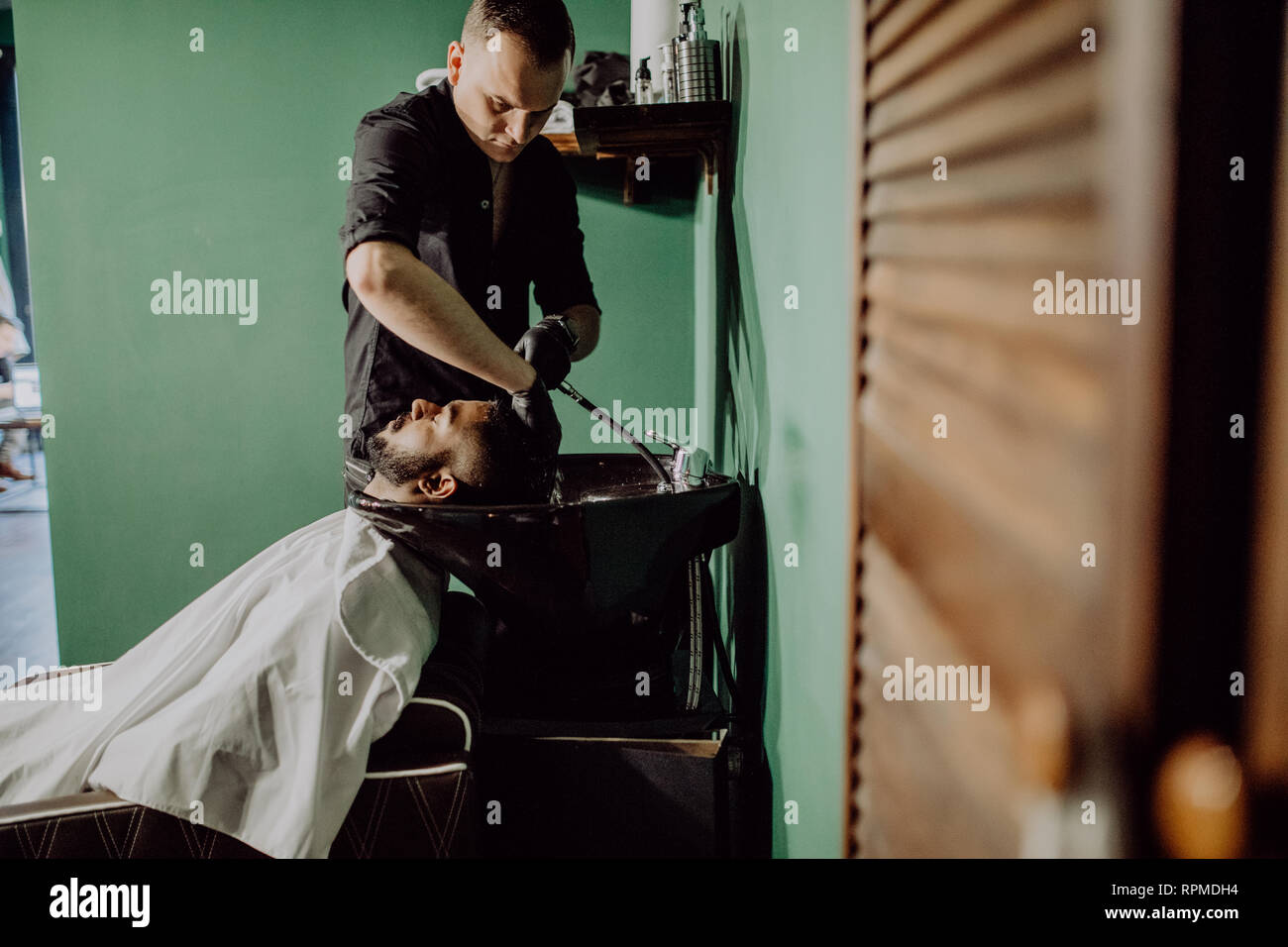 Service beauty. Cropped image of barber combing client in barber shop ...