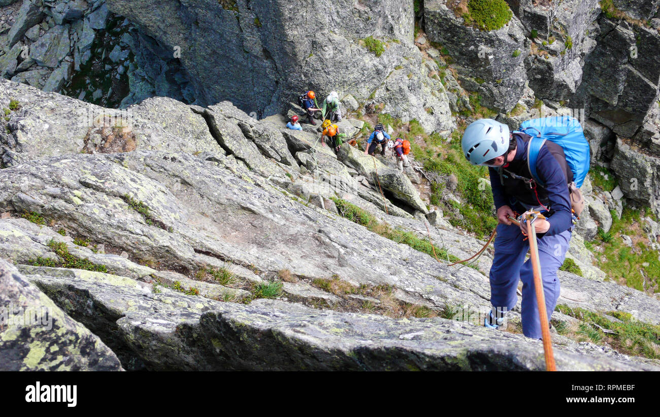 rock climbers traverse and climb the Clocher de Planpraz climbing route ...