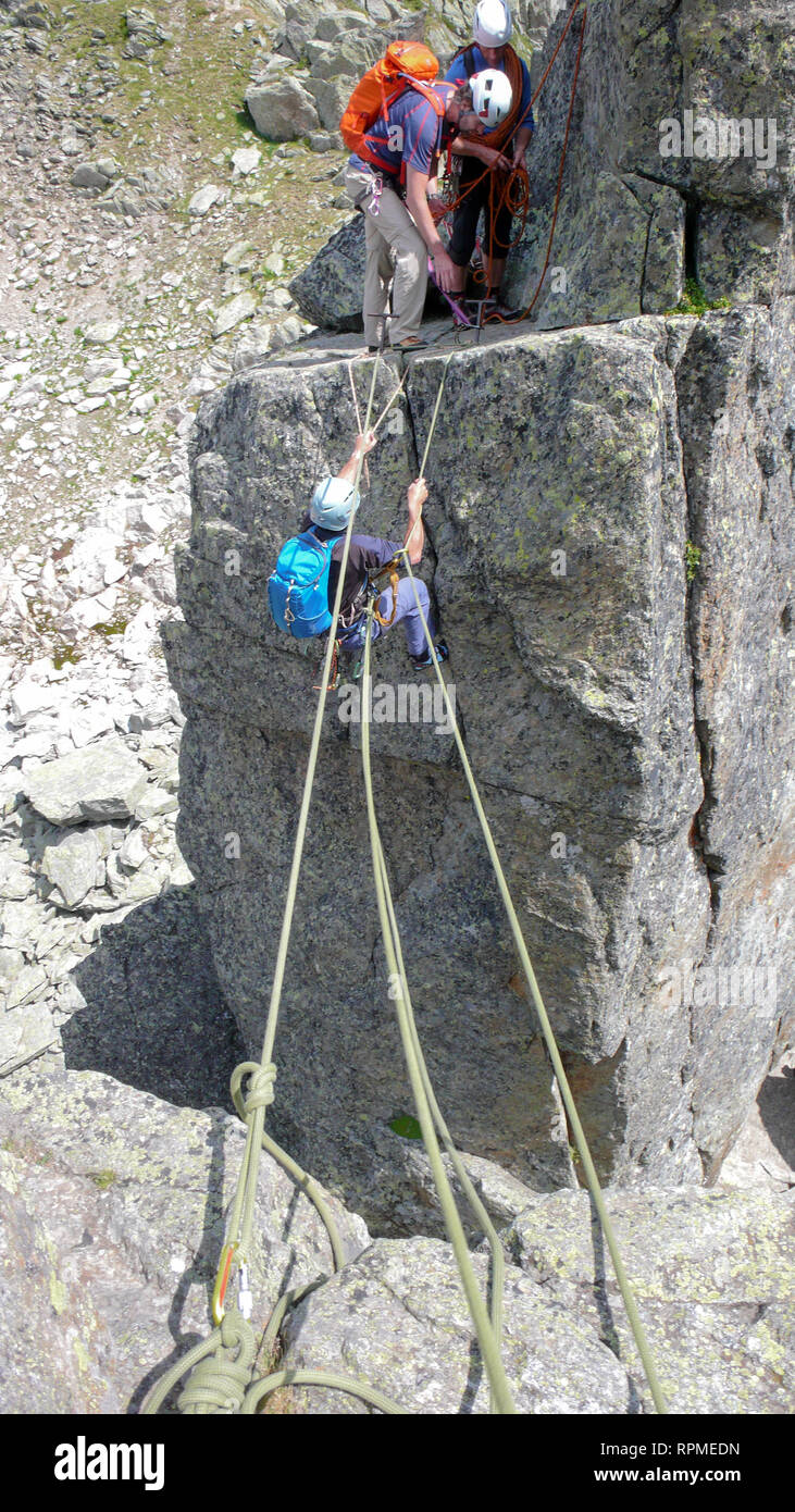 rock climbers traverse and climb the Clocher de Planpraz climbing route ...
