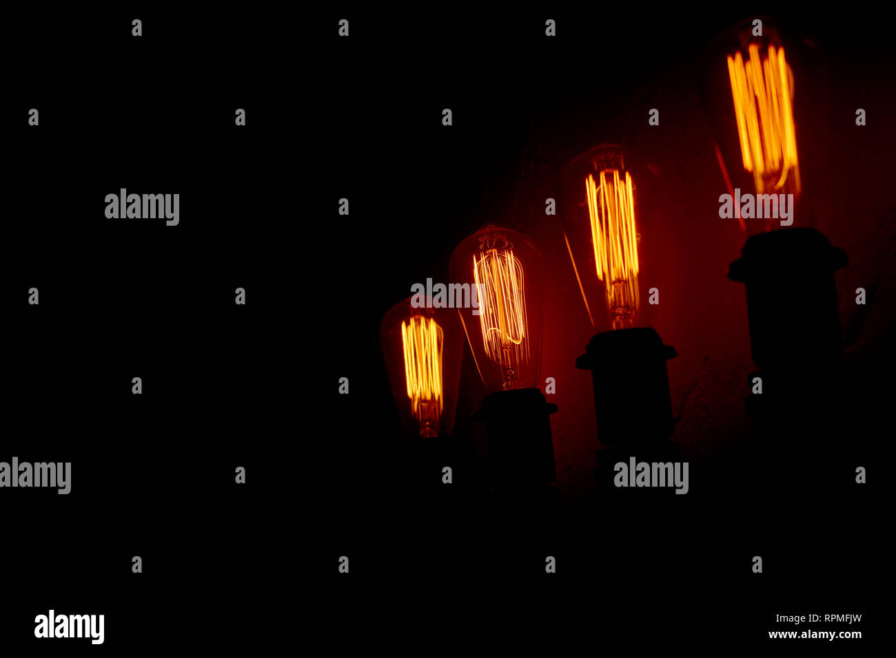 Diagonal arrangement to the right of four Edison style glowing bulb ...
