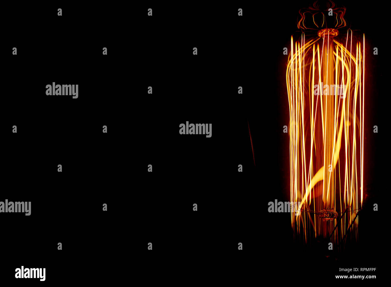 Close up of glowing filaments inside and Edison style bulb set against ...