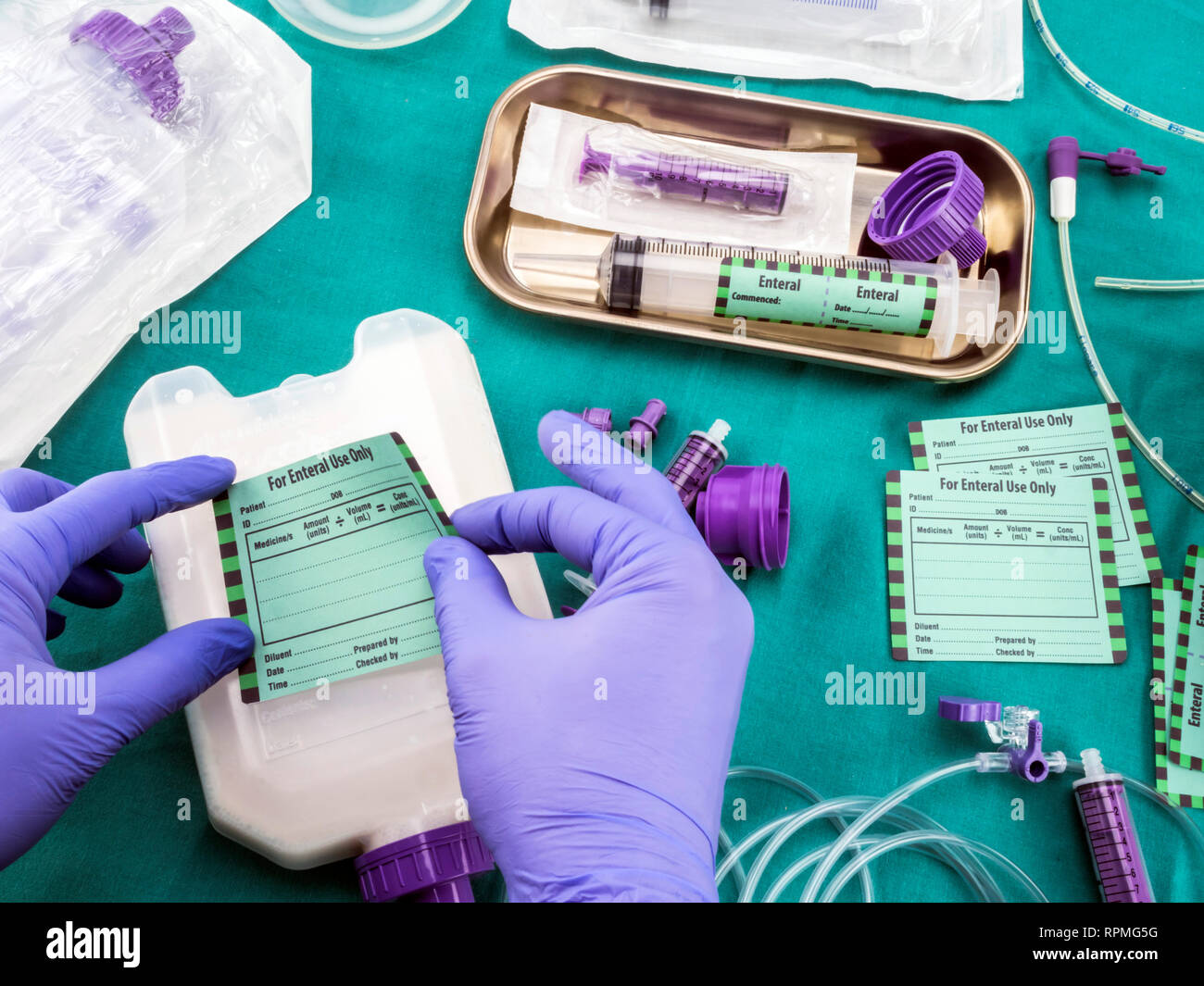 Nurse sticking identification sticker on enteral nutrition bottle ...