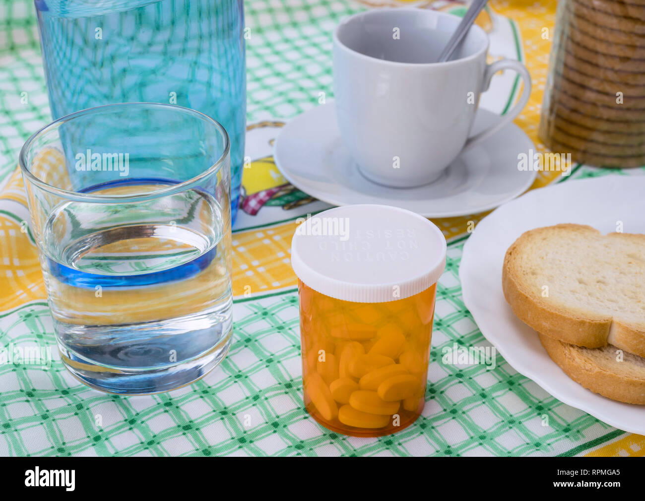 Medication during breakfast, capsules next to a glass of water ...