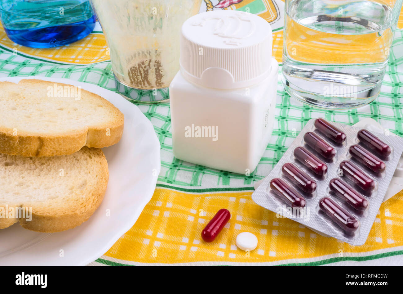 Medication during breakfast, capsules next to a glass of water ...