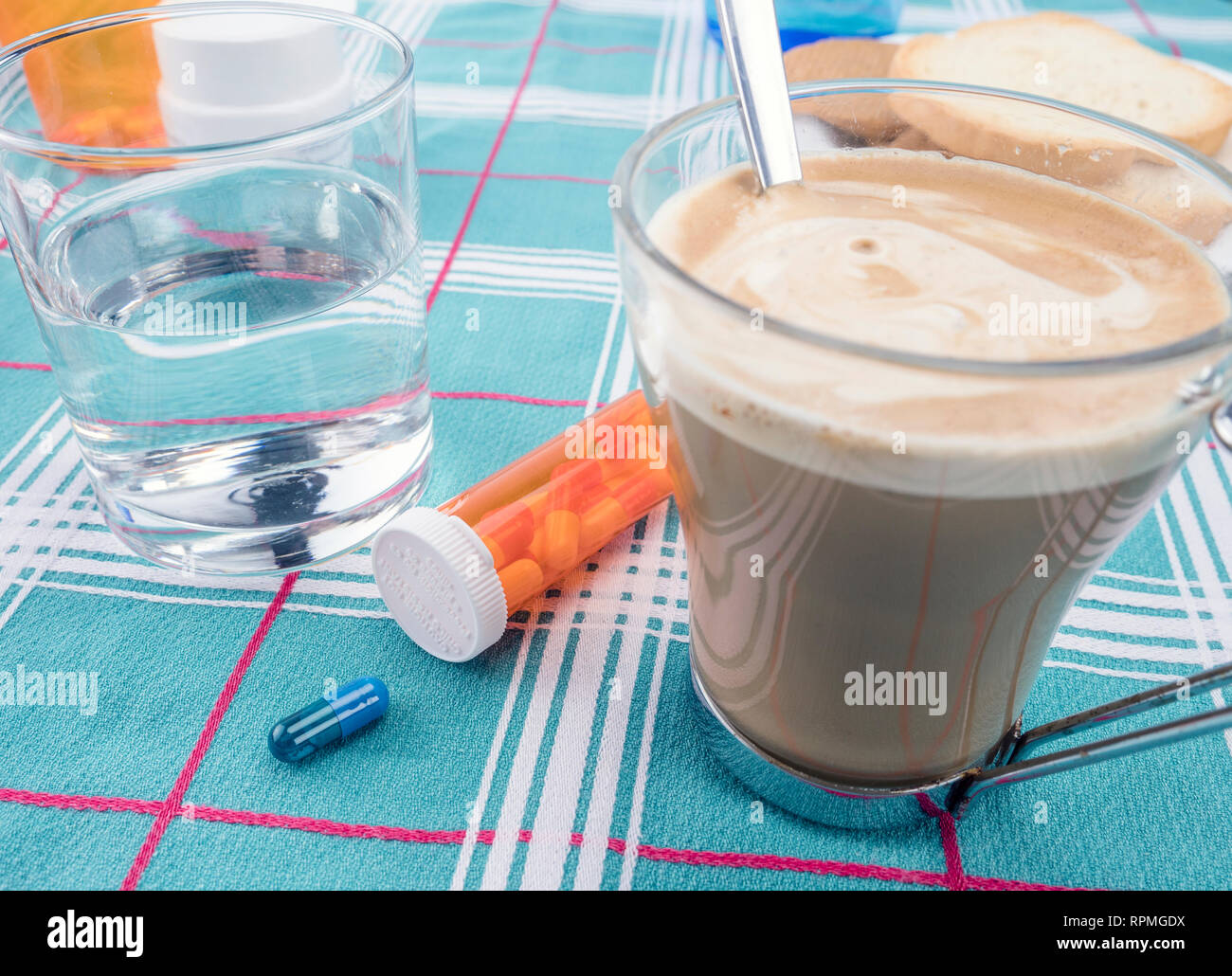 Medication during breakfast, capsules next to a glass of water ...