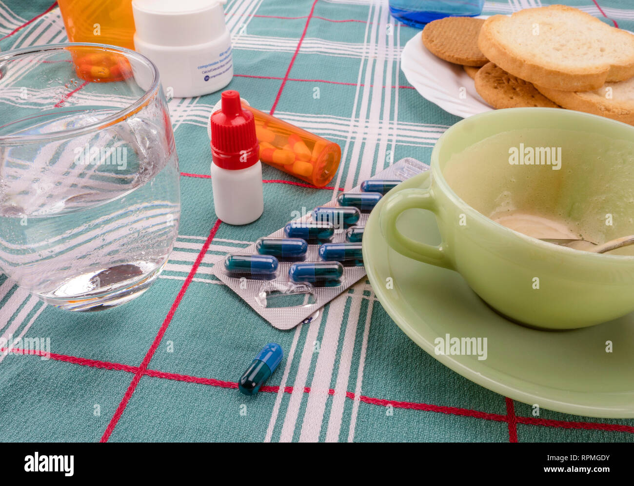 Medication during breakfast, capsules next to a glass of water ...