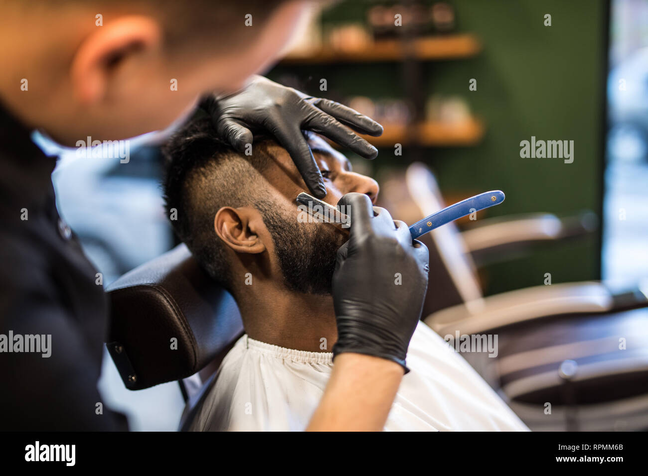 Close-up of barber shearing beard to man in barbershop Stock Photo - Alamy