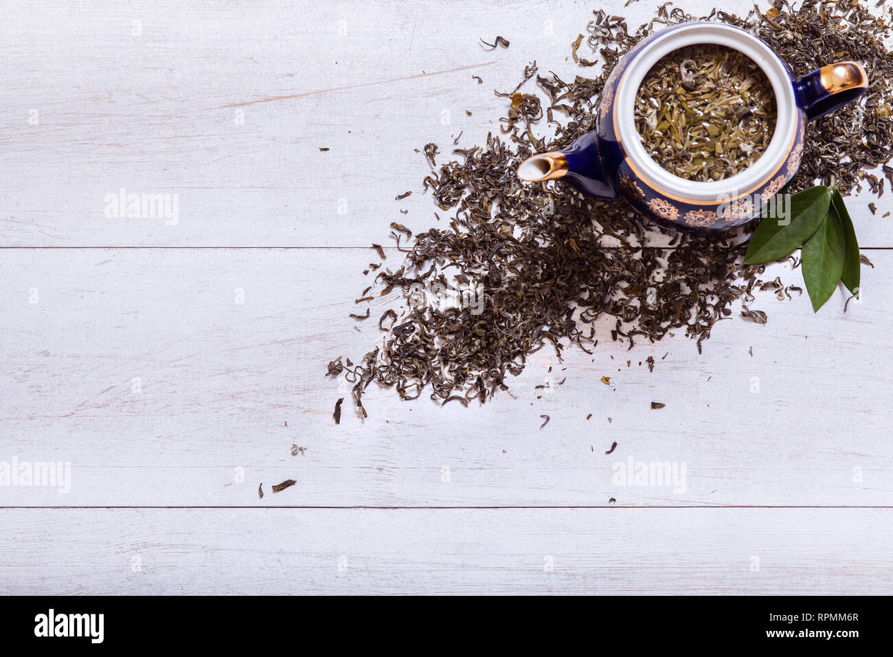 Teapot and dried tea leaves on white wooden background, green tea leaf ...