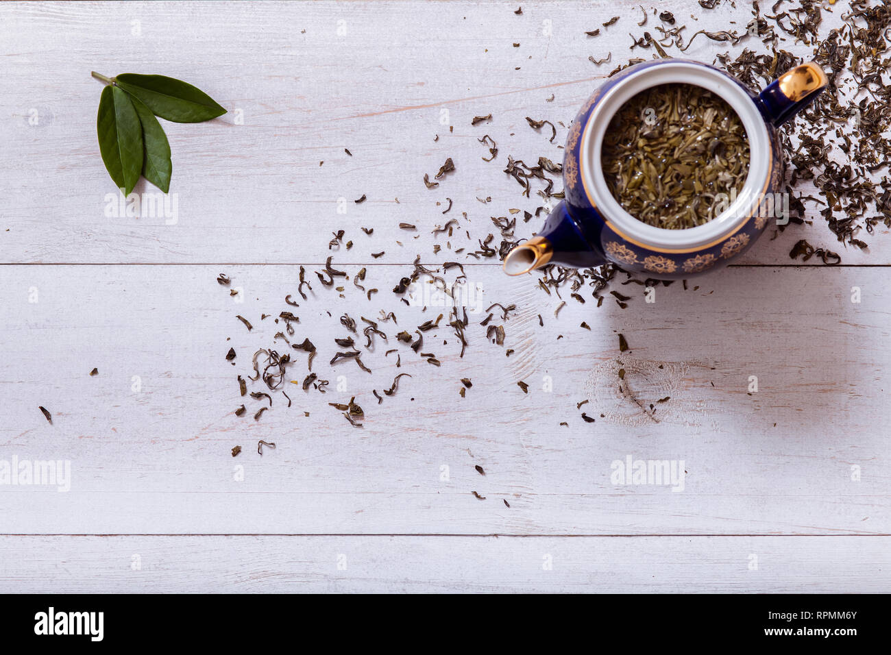 Teapot and dry tea leaves on white wooden background, green tea leaf on ...