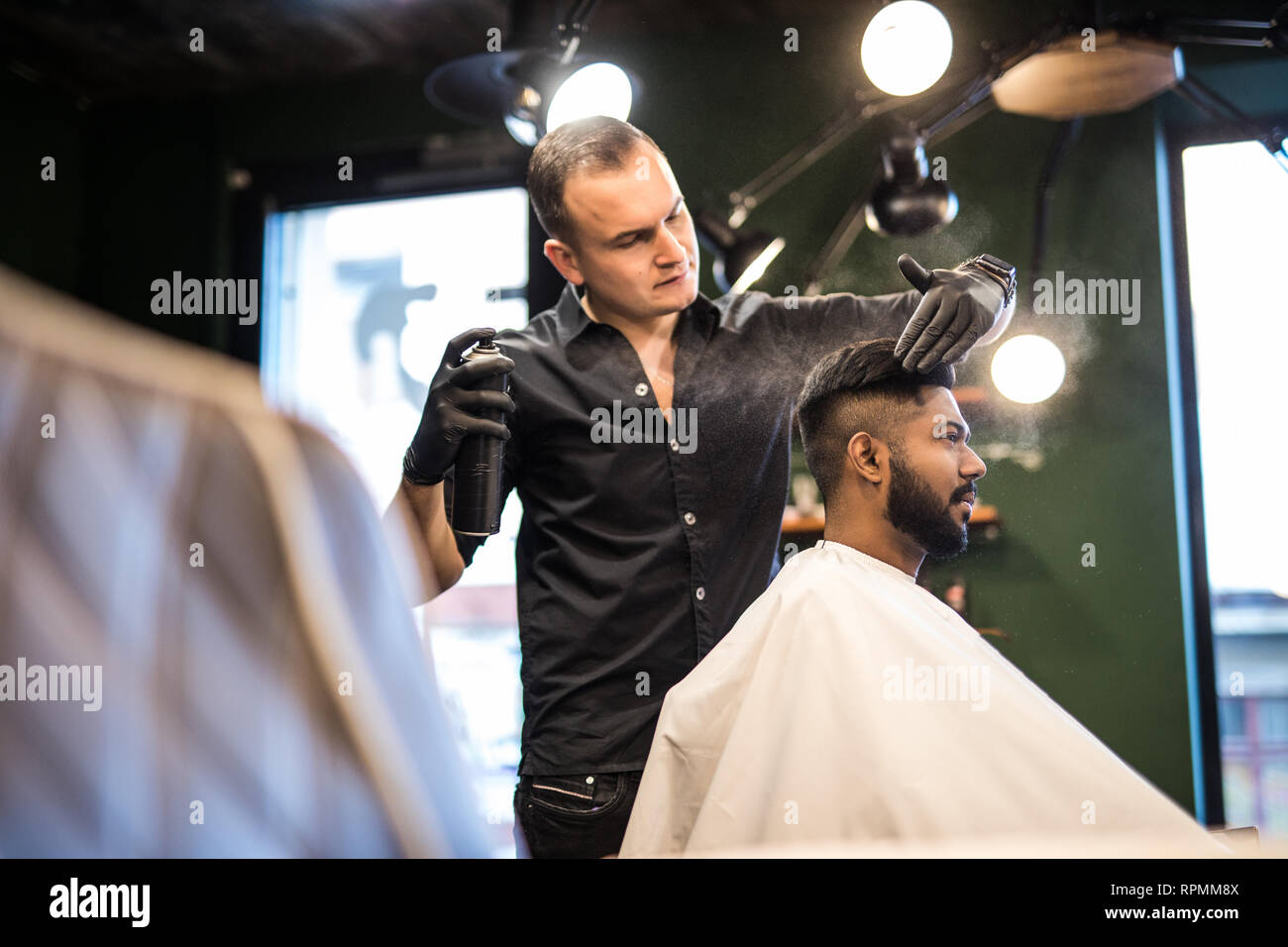 Barber splashes of spray on the client's hair Stock Photo - Alamy