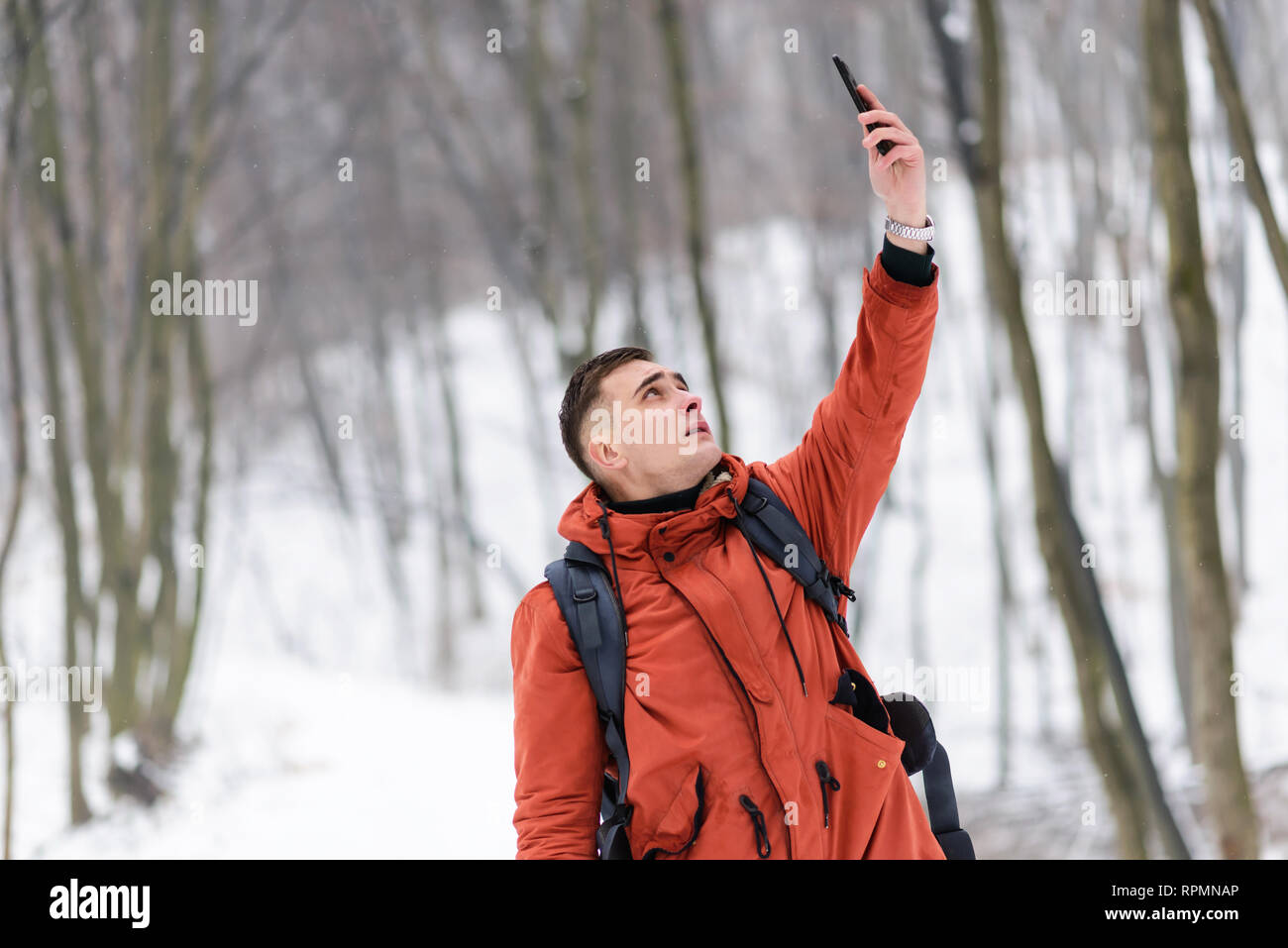 Tourist guy catches a mobile network in the cold winter forest Stock ...