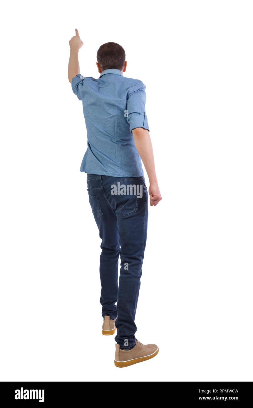 Back view of a man in jeans points his hand upwards. Rear view people ...