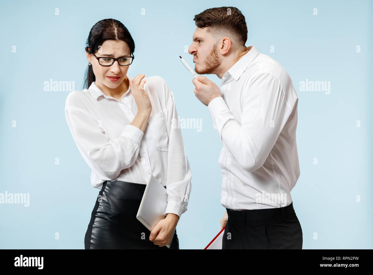 Angry boss. Man and his secretary standing at office or studio ...