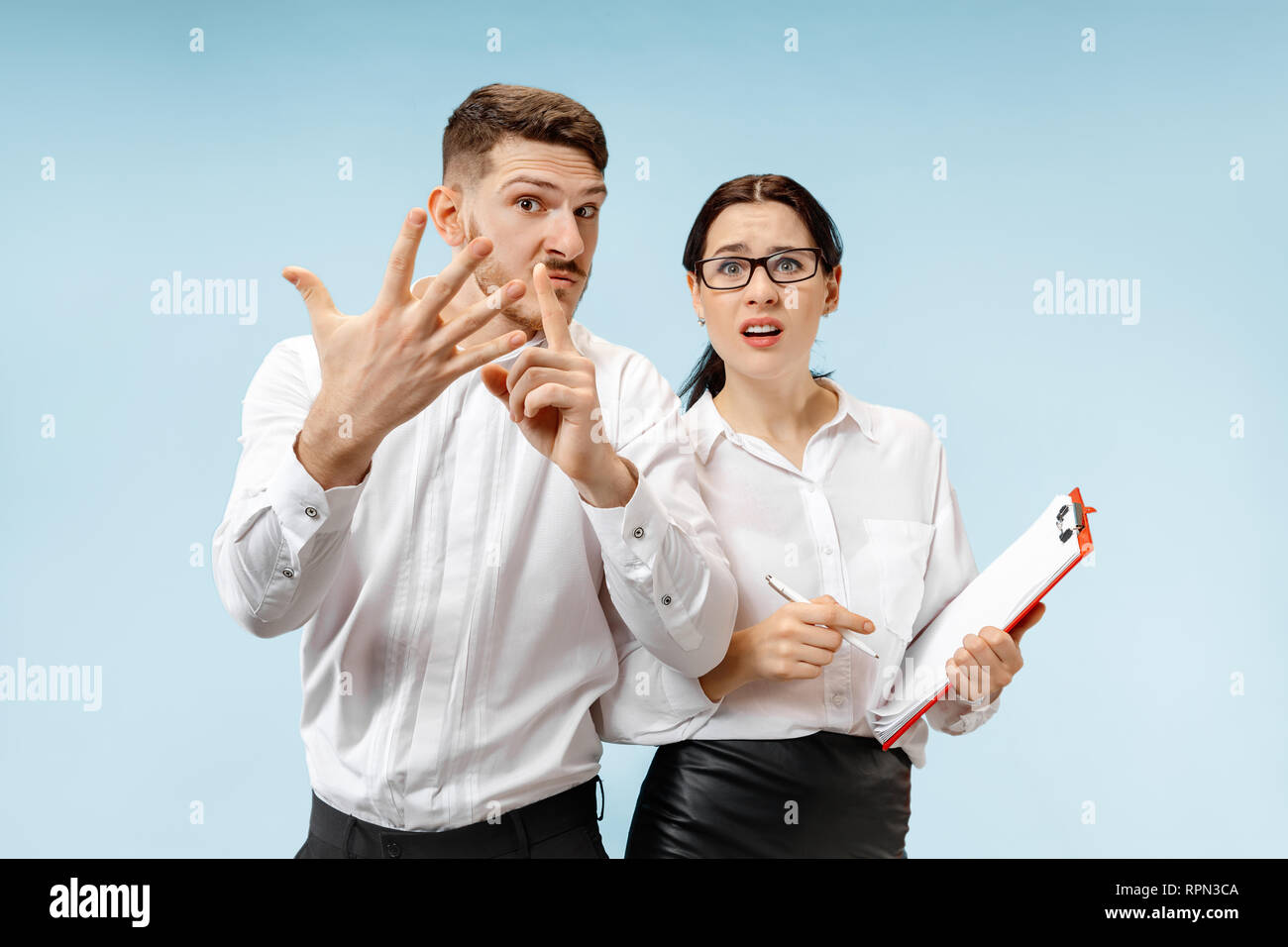 Angry boss. Man and his secretary standing at office or studio ...