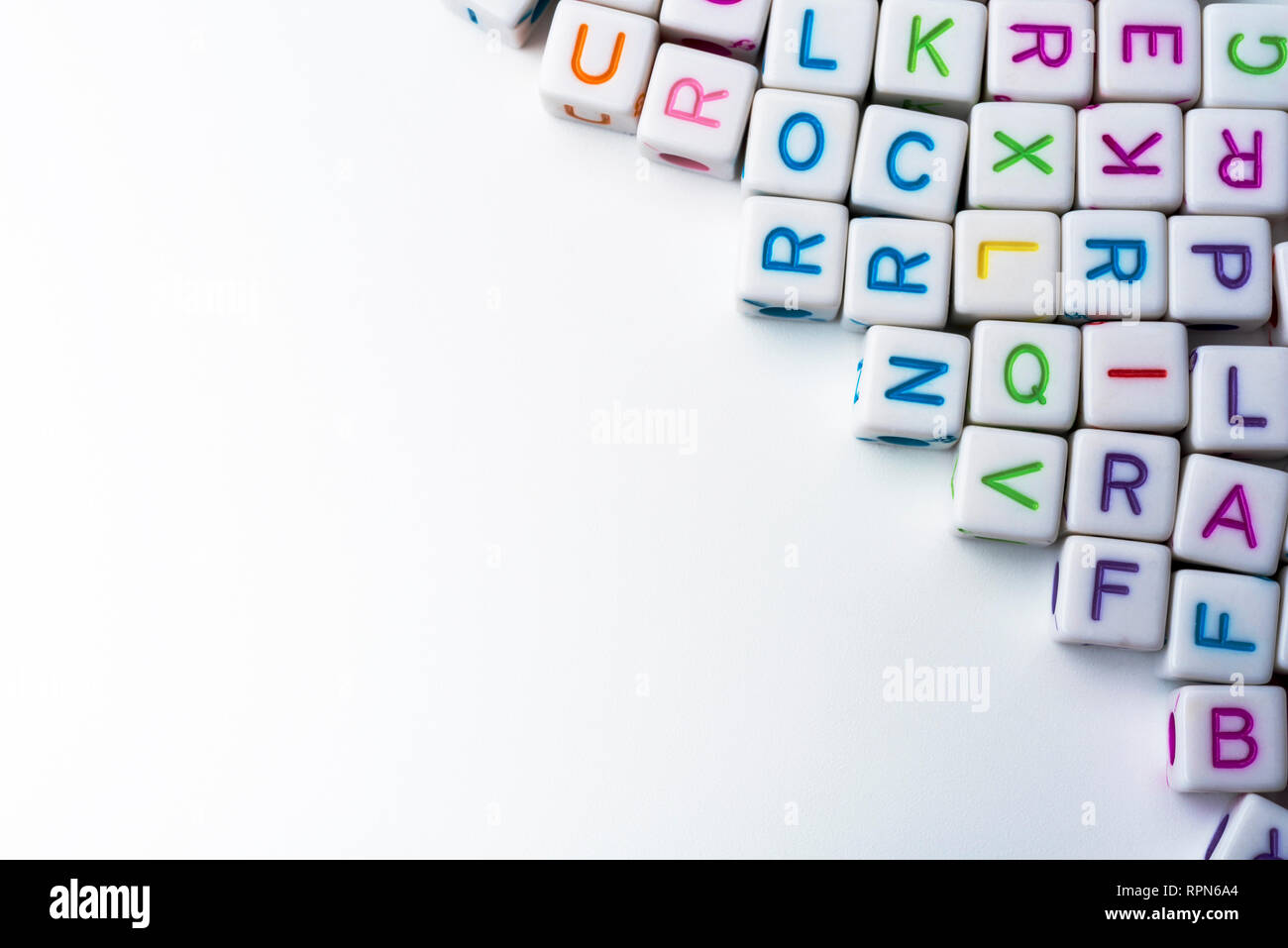 Lots of colorful decorative cubes with letters on white background. The ...