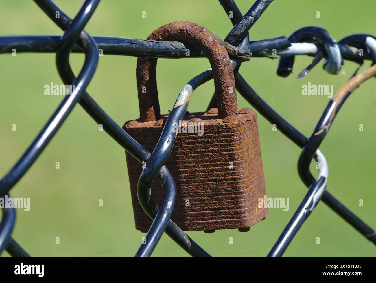Dirty old corrosive padlock on wire mesh fence Stock Photo - Alamy