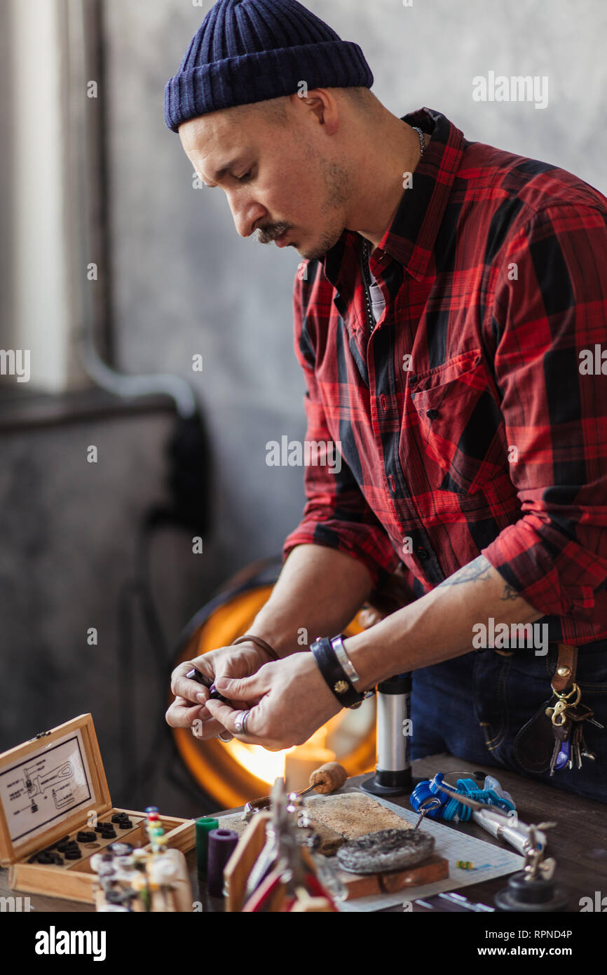 serious craftsman checking his tools at work. close up side view photo ...