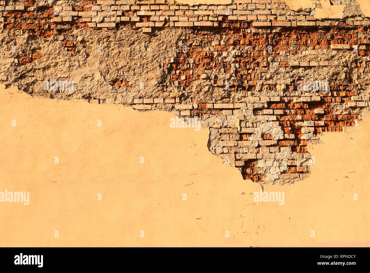crumbling old plaster on a brick wall red orange background Stock Photo ...