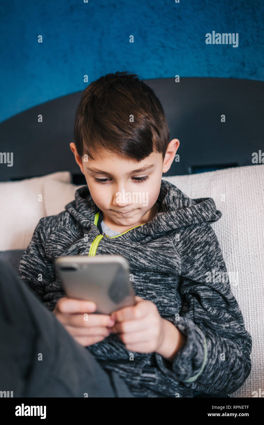Little boy using smartphone in his home Stock Photo - Alamy