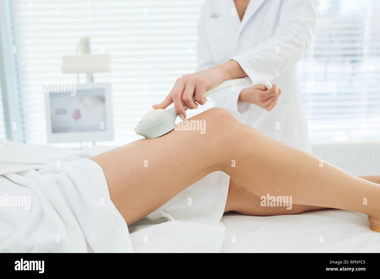 Unrecognizable female cosmetologist doing Rf lifting procedure on woman ...