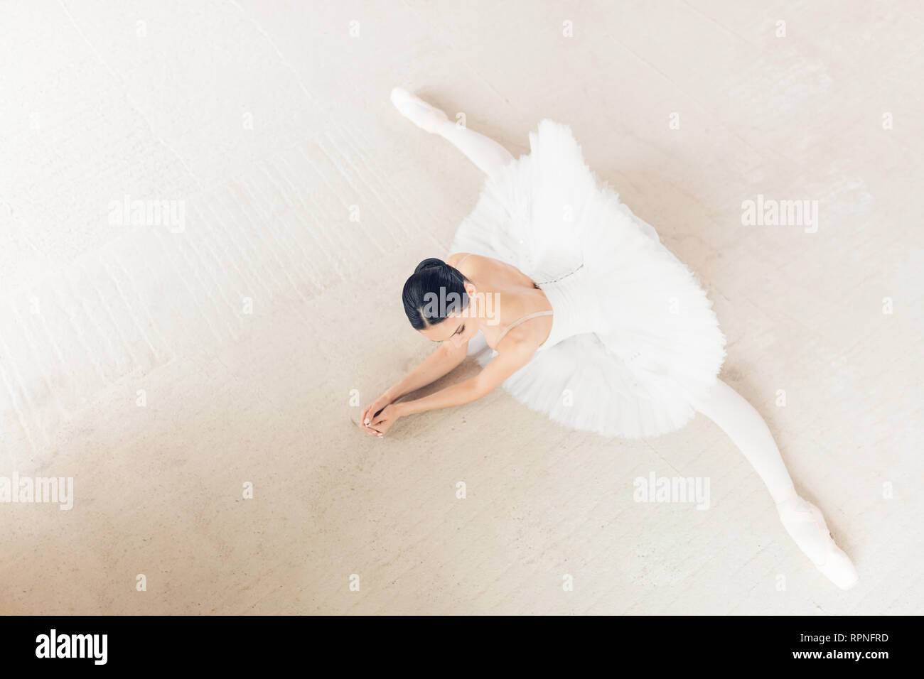 top view photo. young ambitious ballerina doing splits exercise in the ...