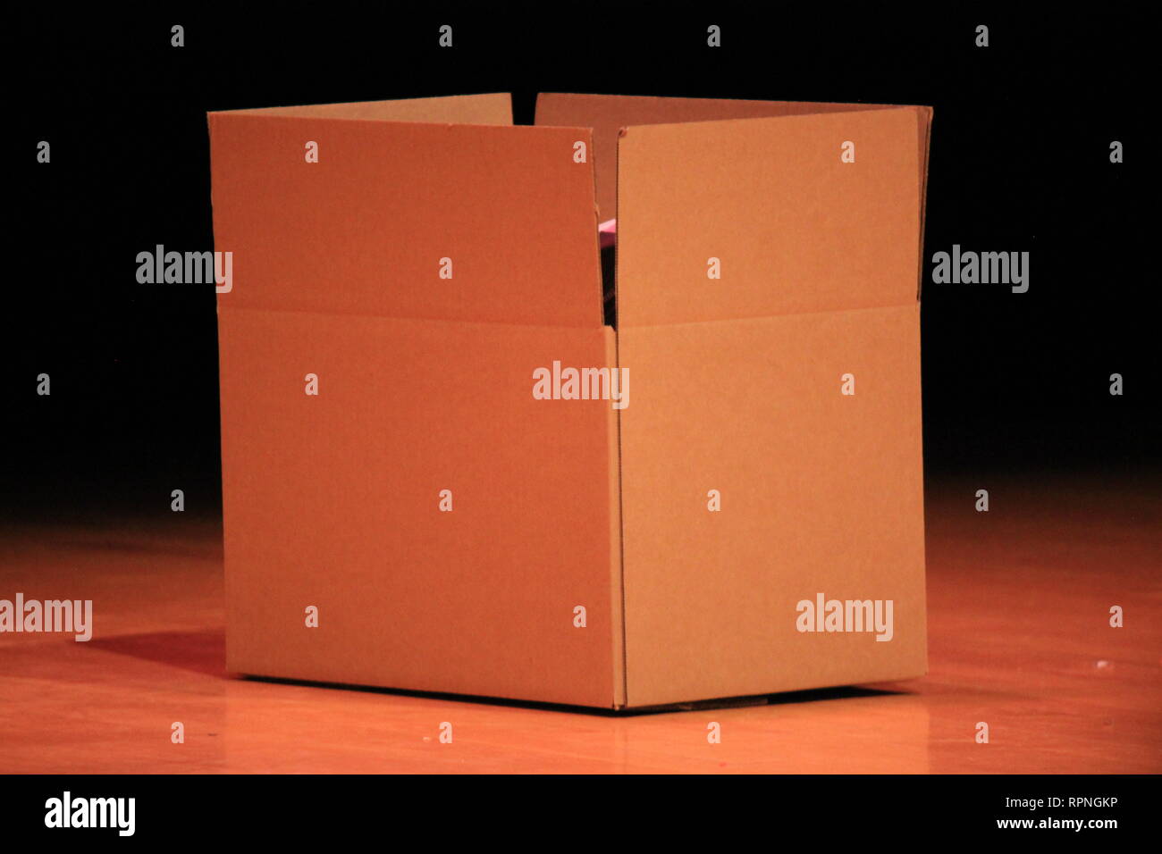 Plain brown open cardboard box set on a well lit stage Stock Photo - Alamy