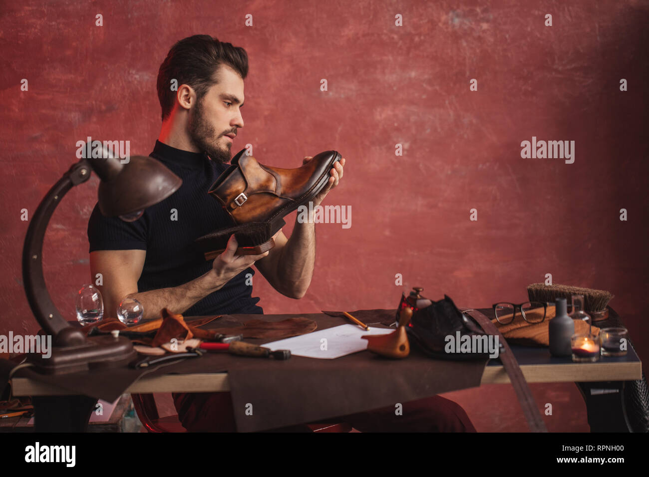 attractive guy holding boots and checking them, close up photo. copy ...