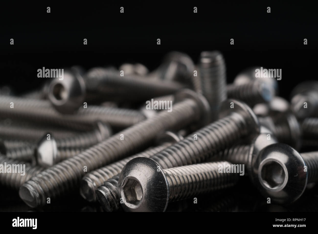 Screw and bolts on black background Stock Photo - Alamy