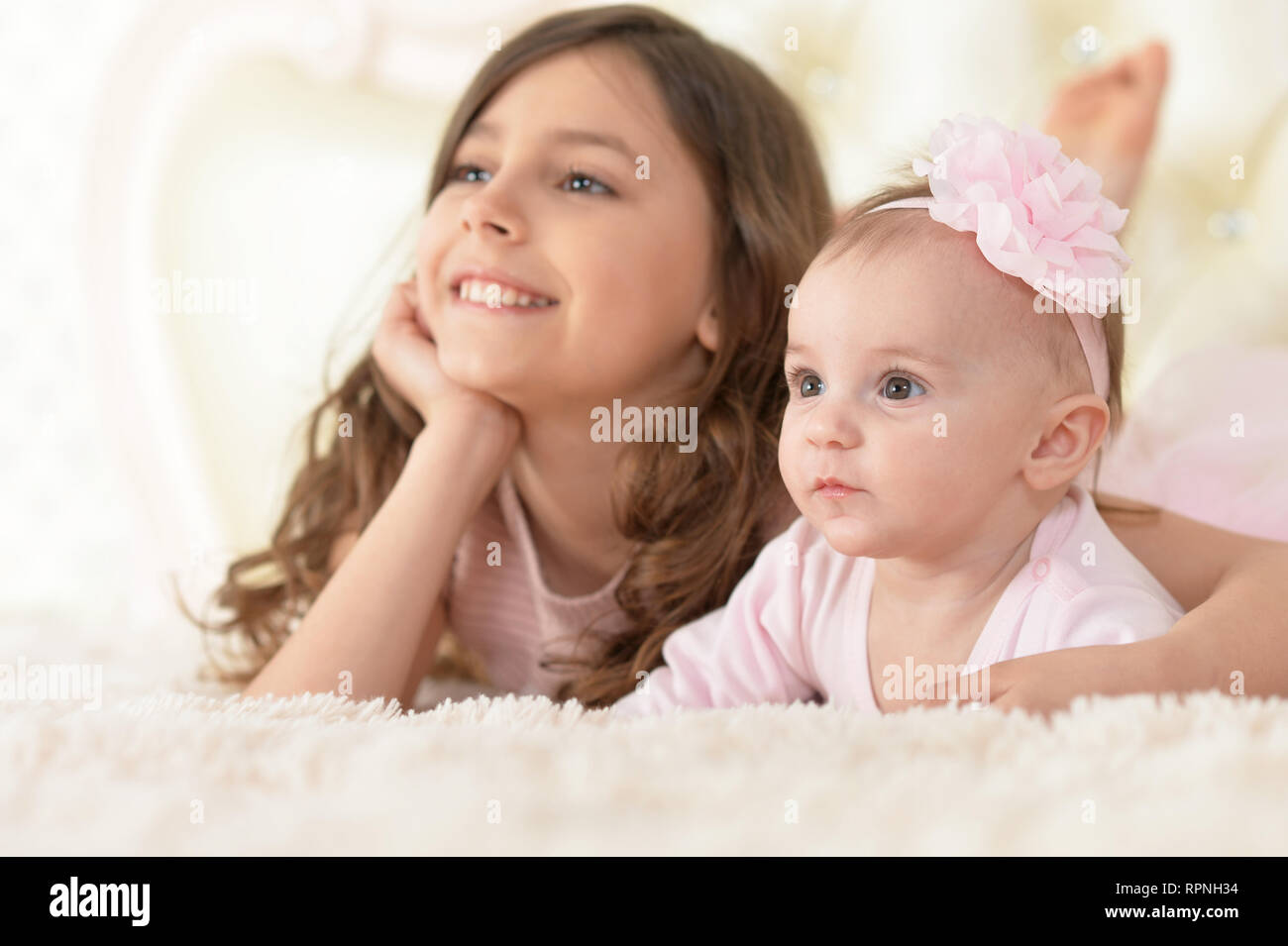 Two beautiful cute sisters posing in bed at home Stock Photo - Alamy