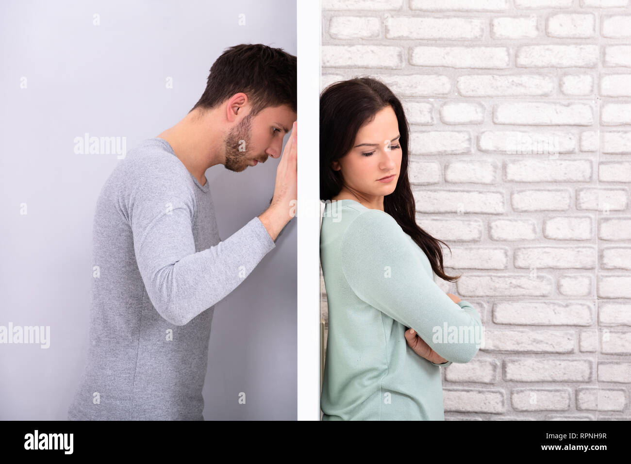 Side View Of Young Unhappy Couple Standing Back To Back At Home Stock ...