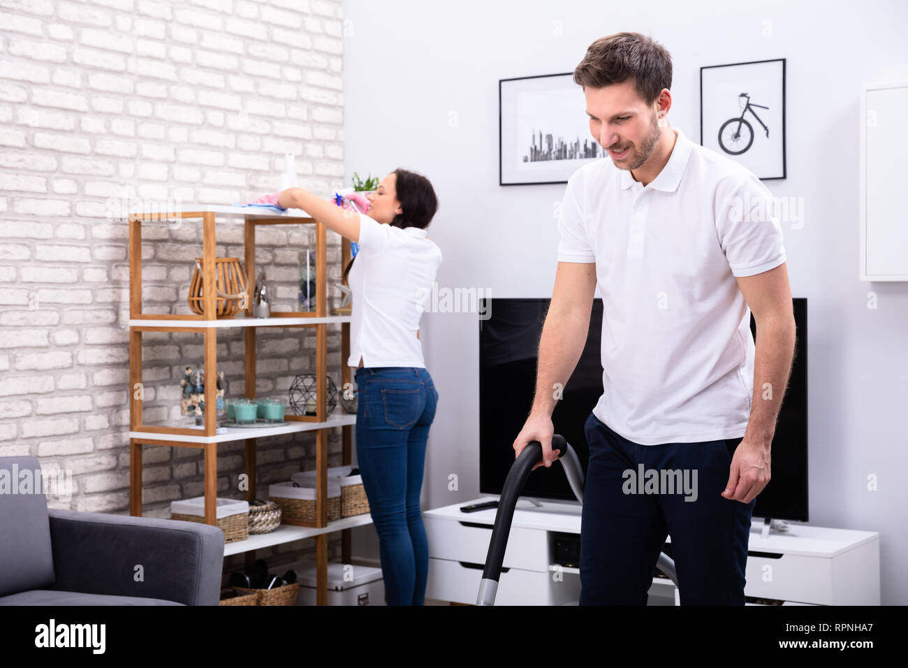 Side View Of Two Persons Cleaning The Shelf And Mopping Floor In The ...