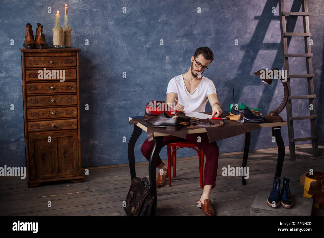 Leather craftsman writing a letter to a customer , full length photo ...