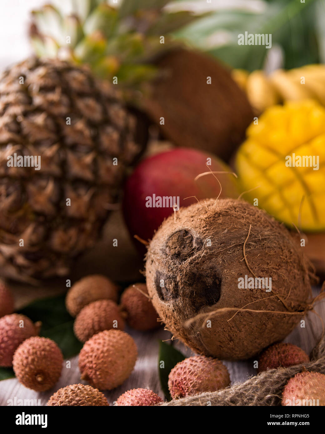 Fresh tropical fruit on wood top view. bananas, pineapple, coconut ...